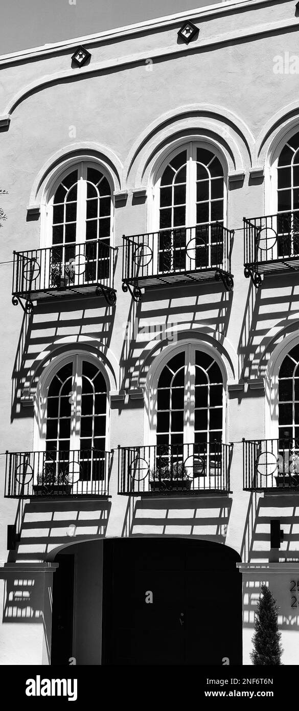 A vertical greyscale of the shadow of balcony fences of a building in ...