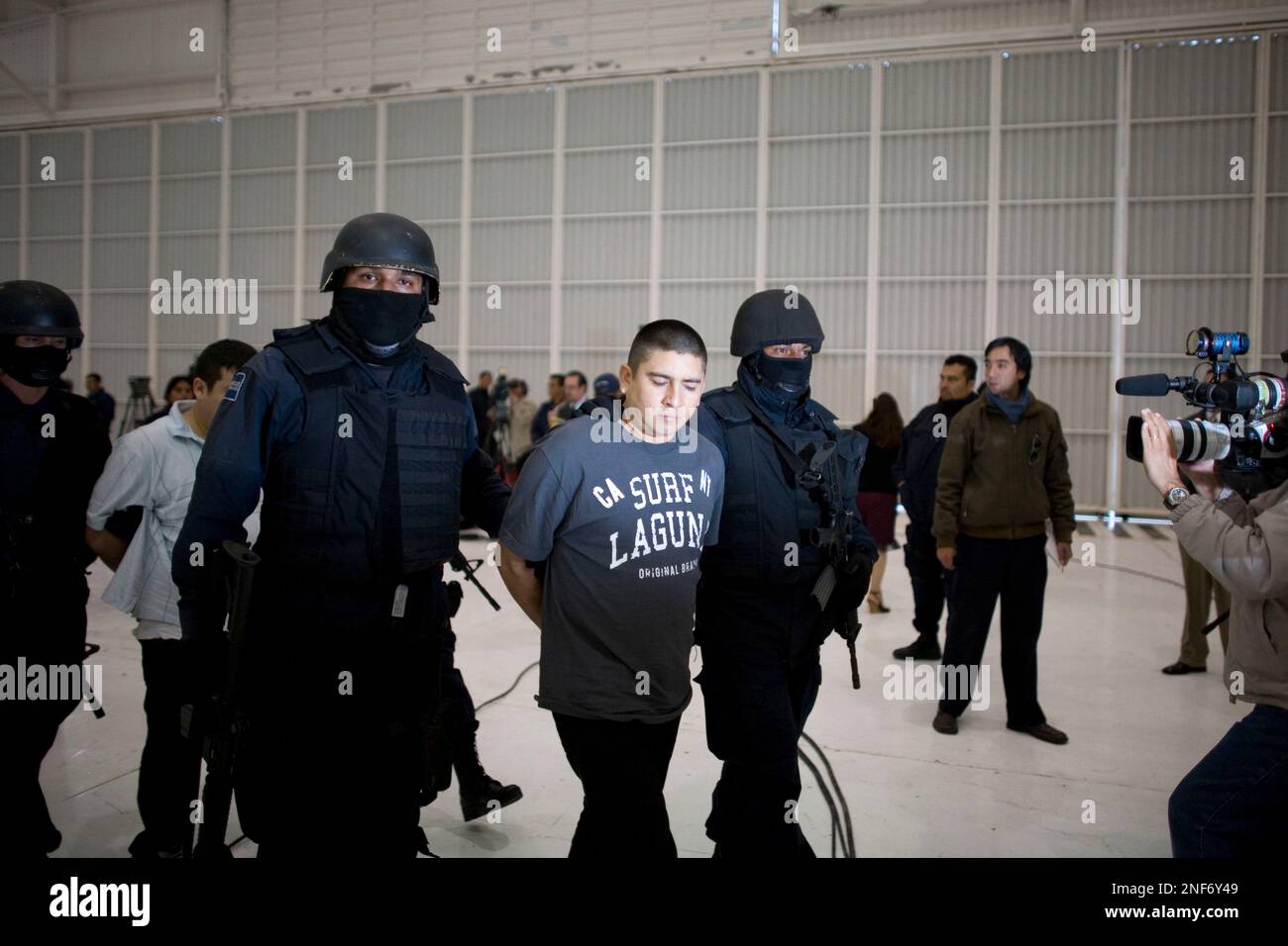 Federal police agents escort Victor Escalante, center, an officer of ...