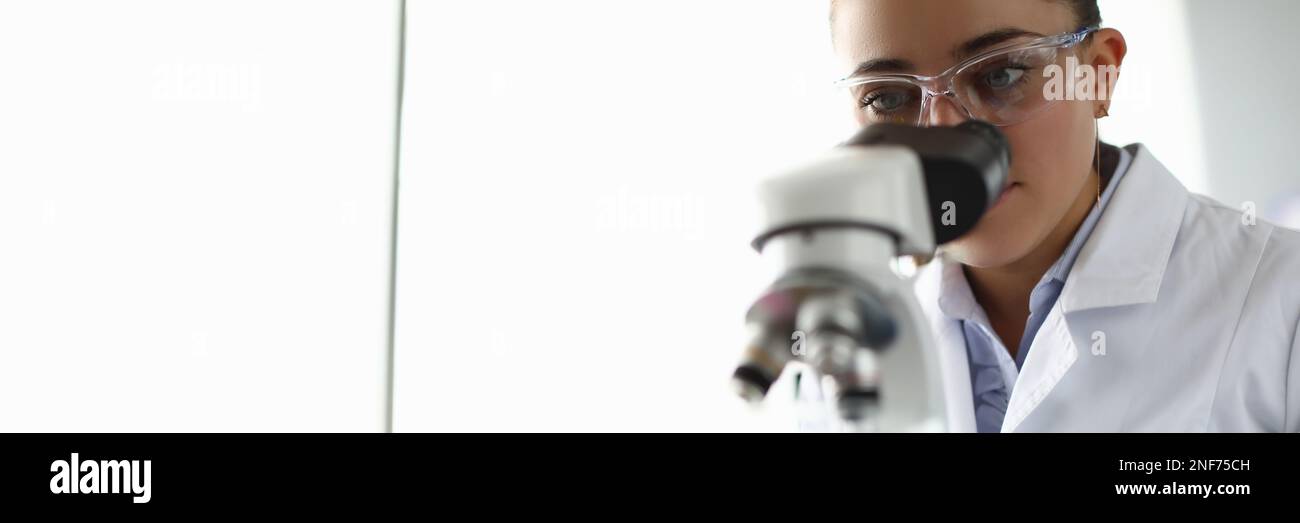 Young woman scientist looks into microscope in laboratory Stock Photo ...