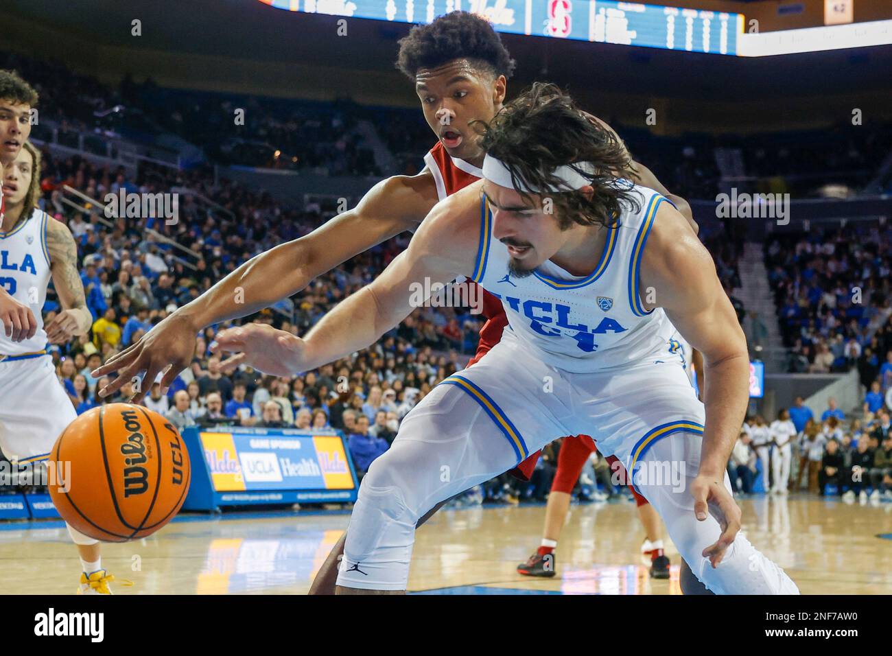 UCLA guard Jaime Jaquez Jr. (24) and Stanford forward Harrison Ingram (55) fight for the ball ...