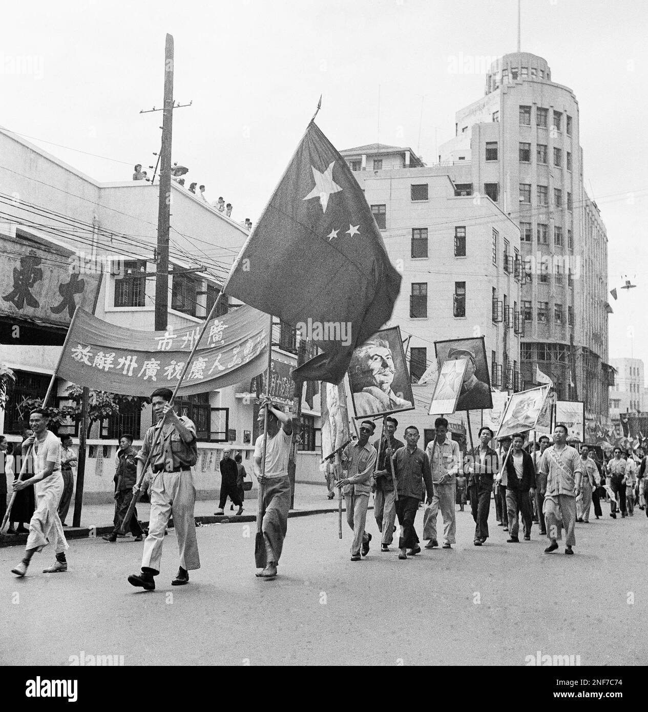 Carrying banners and portraits of Stalin and Chinese Communist leaders ...