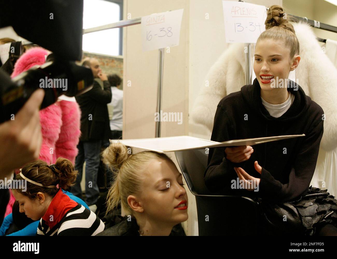 A model jokes as she poses for a photographer in the backstage of the ...
