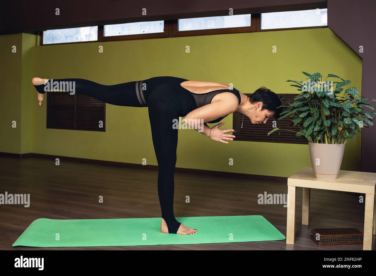 Middle-aged woman leads a healthy lifestyle and does yoga, performs ...