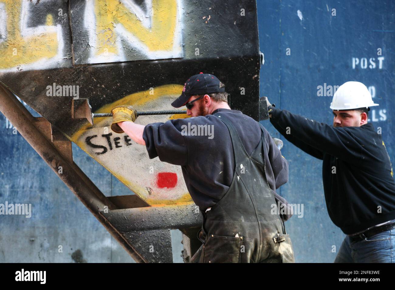 Richard Farrell, left, and Chris Arena manuever a bucket of liquid ...