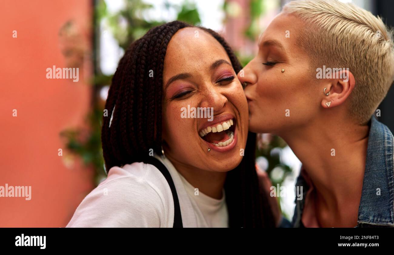 I love my bestie. an attractive young woman kissing her friend on the ...