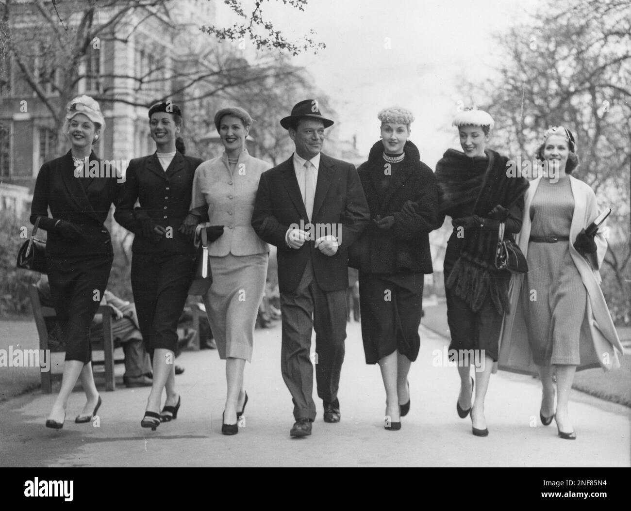 U.S. American actor and singer Eddie Constantine, locks arms with six ...