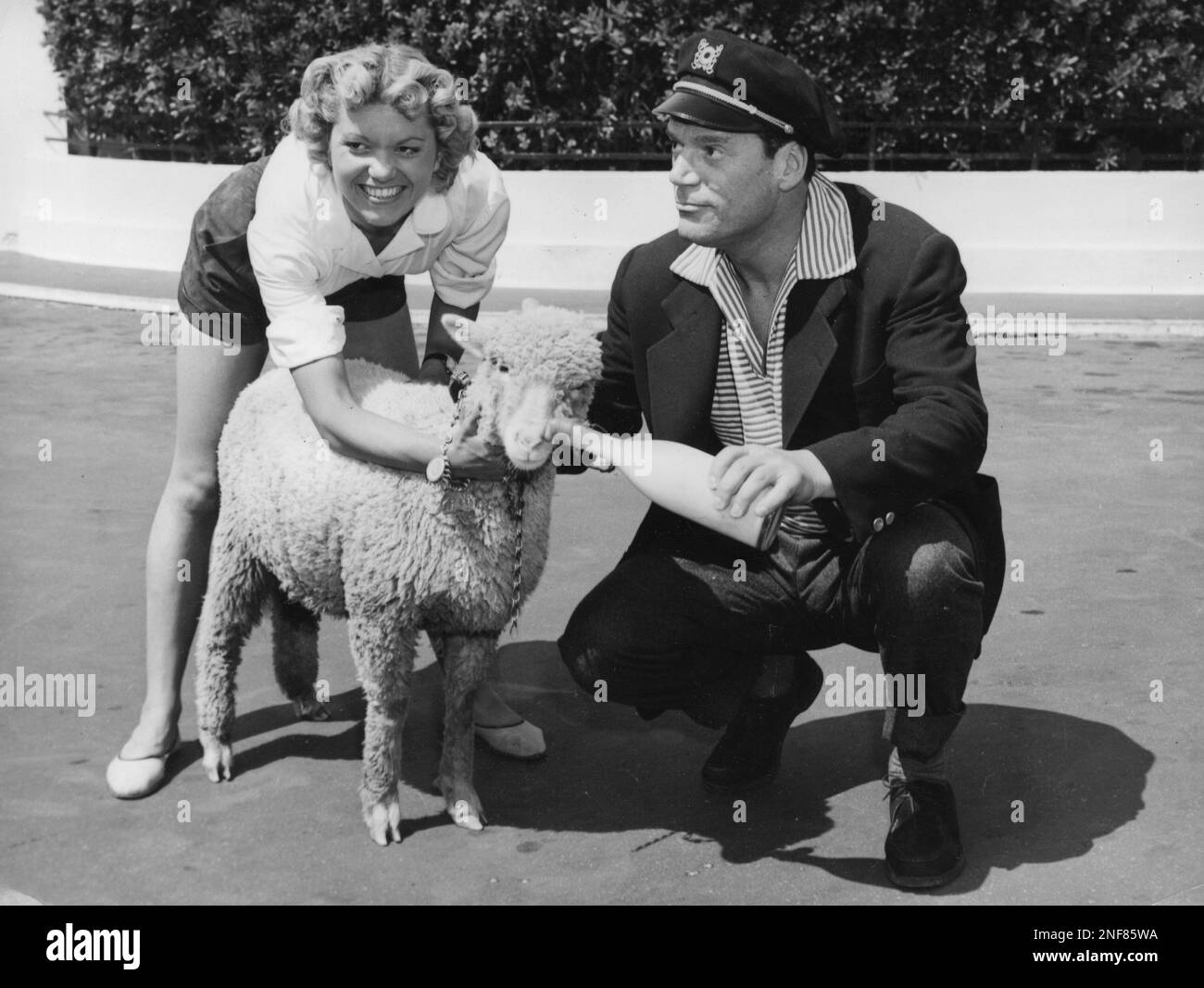 U.S. American actor and singer Eddie Constantine, right, bottle feeds ...
