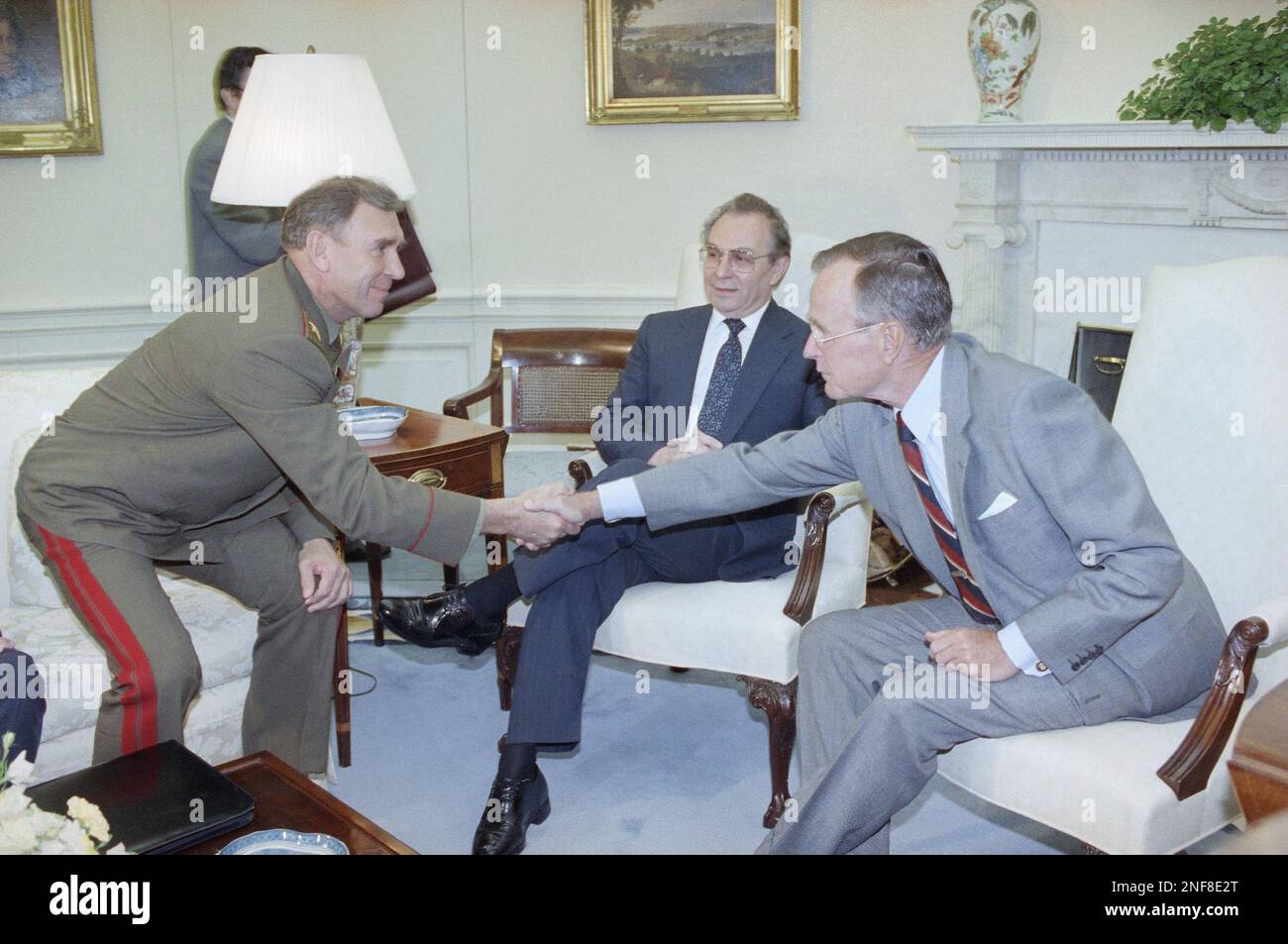 Soviet Gen. Mikhail Moiseyev rises to shake hands with President George ...