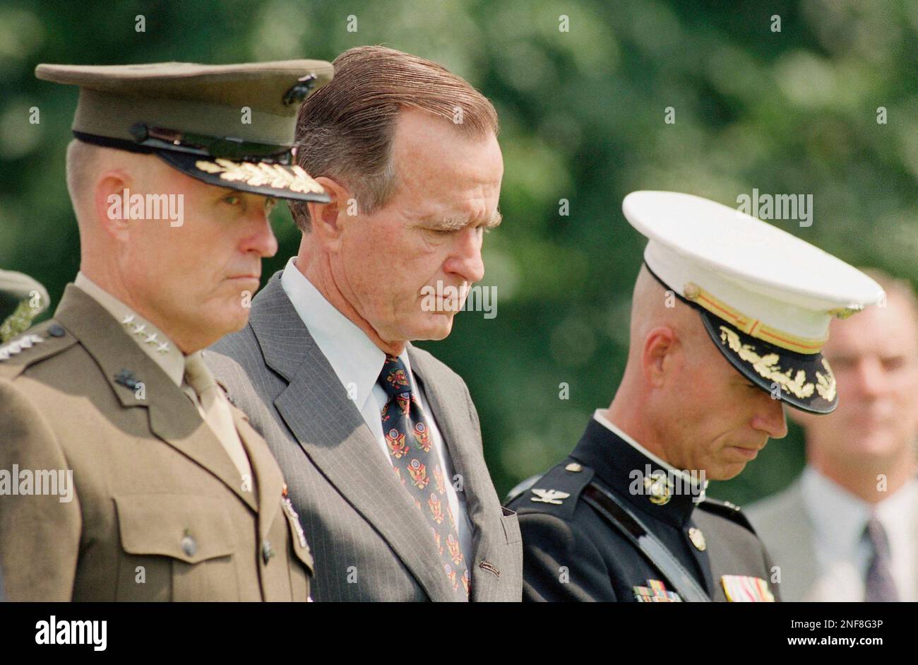 President George Bush, flanked by Gen. Carl Mundy, commandant of the Marine Corps, left, and ...