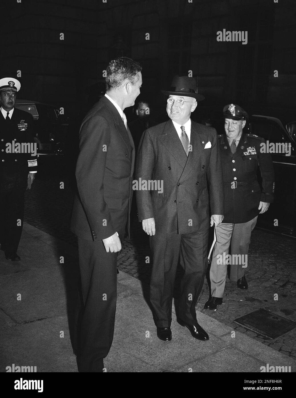 President Harry Truman talks with an unidentified man as he arrives for ...