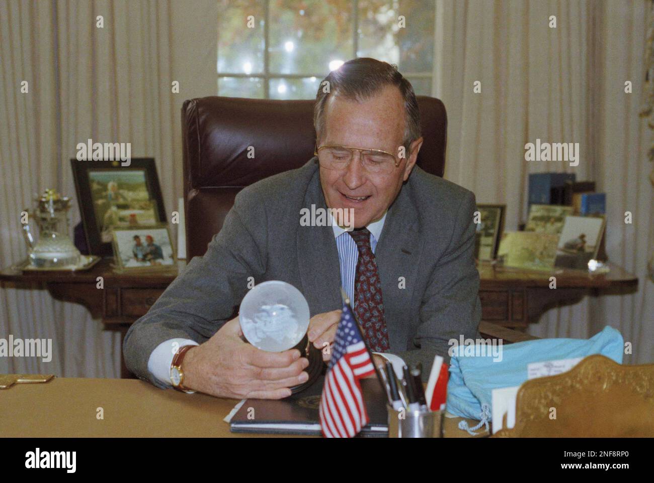 U.S. President George H. Bush looks over a crystal globe presented to ...