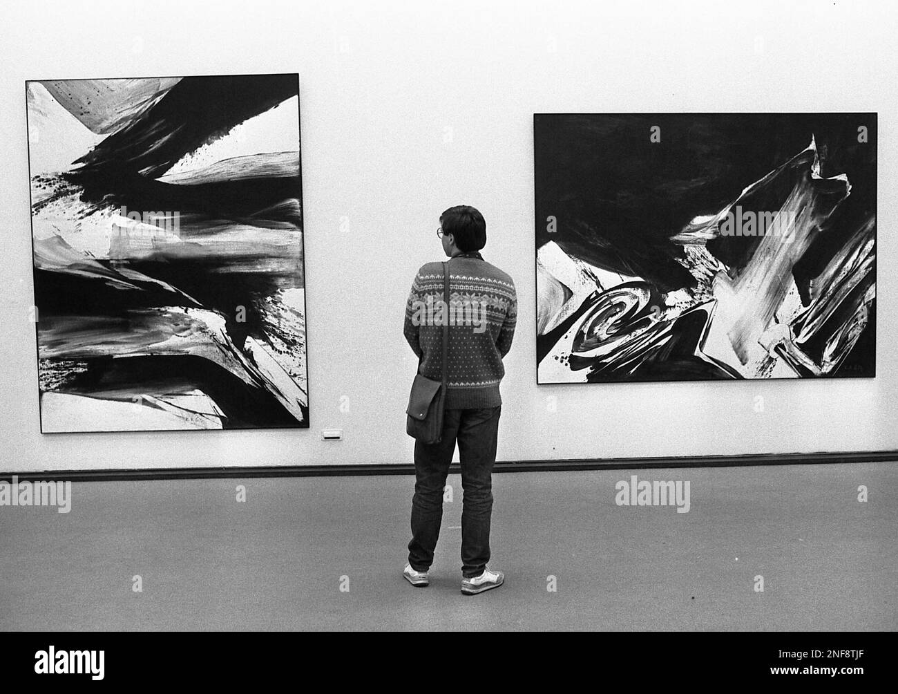A visitor looks at two paintings by German artist Karl Otto Goetz, left ...