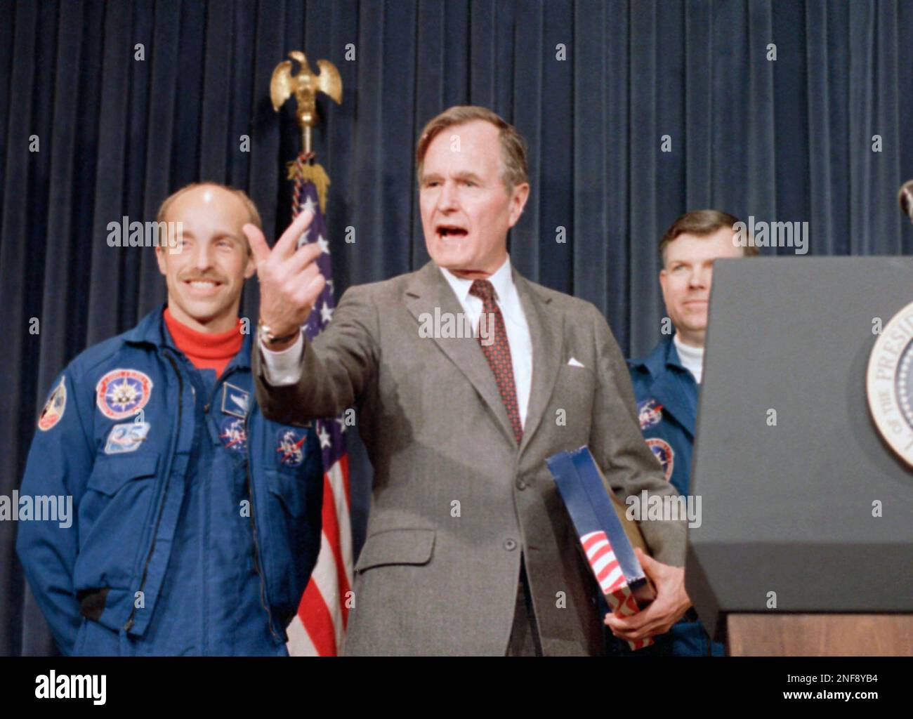 President George Bush gestures after meeting with crew members of the ...
