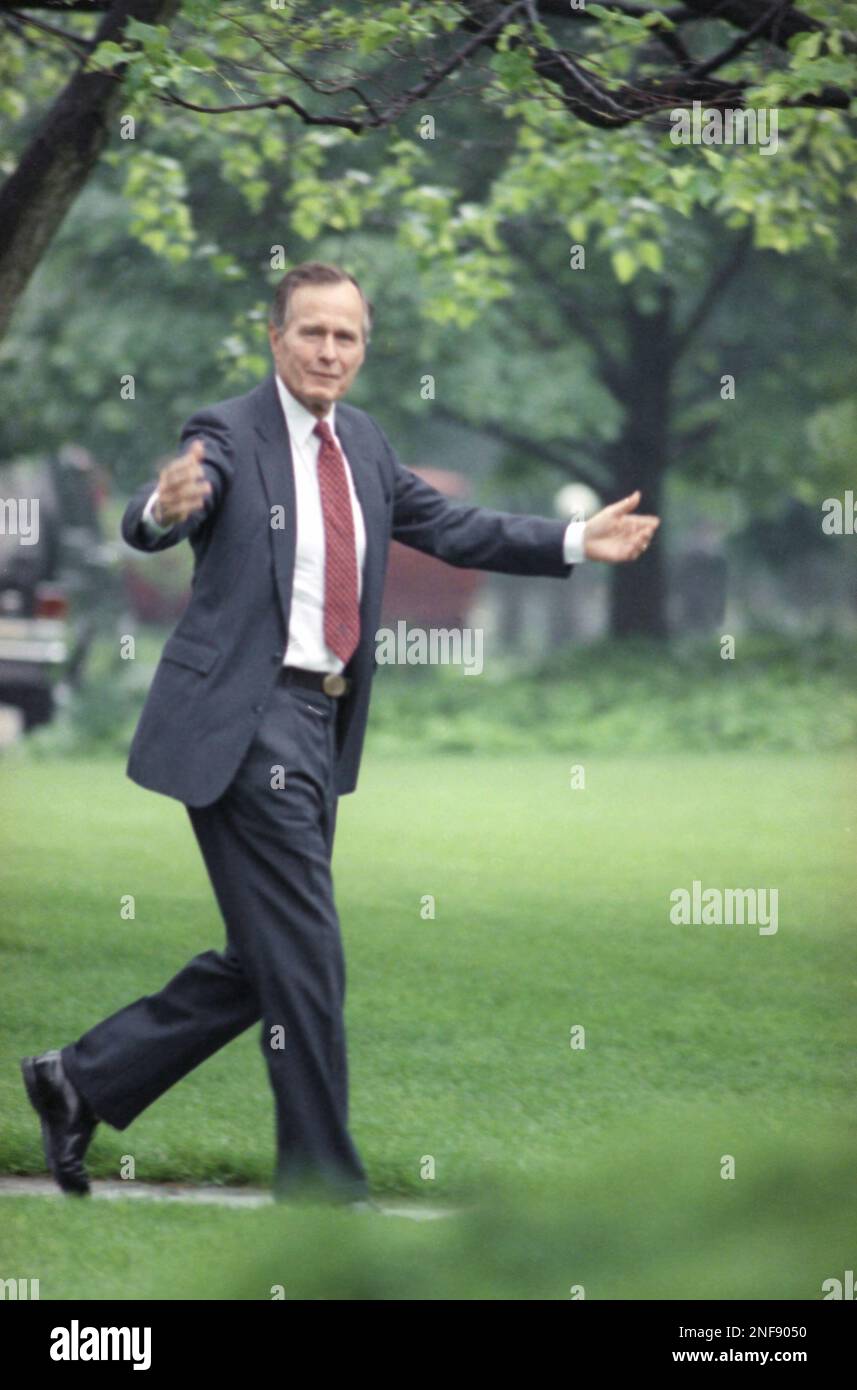 President George Bush gestures as he walks to the Oval Office on his ...