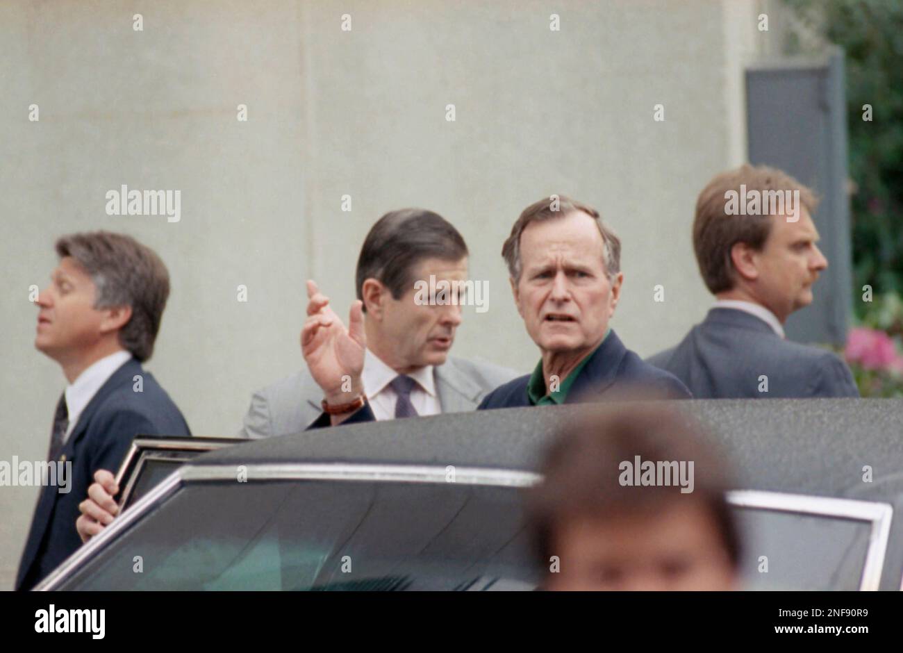 President George Bush, accompanied by a Secret Service agent, leaves ...