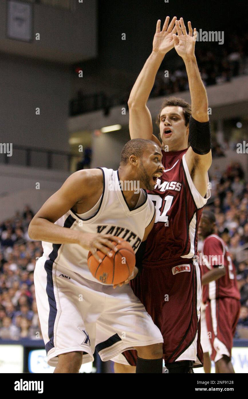 Xavier center Jason Love, left, drives against Massachusetts center ...