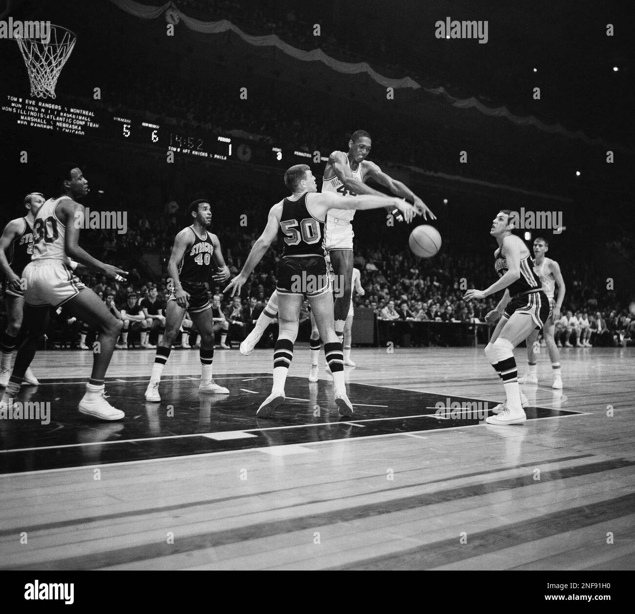 Rebounding basketball eludes the grasp of both Rick Dean (50) of ...