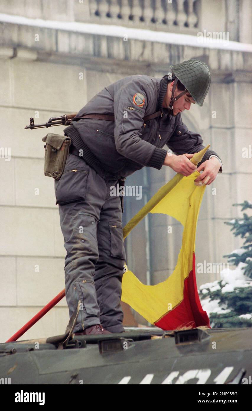 A Romanian soldier folds the national flag on top of his tank at Palace ...