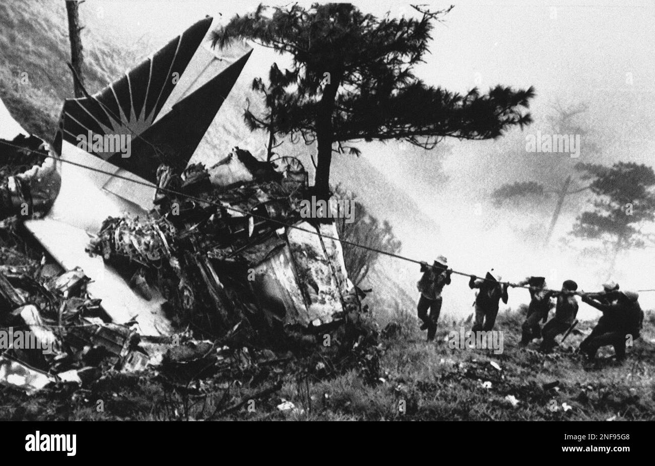 Filipino workers use a cable to remove portions of the wreckage of a ...