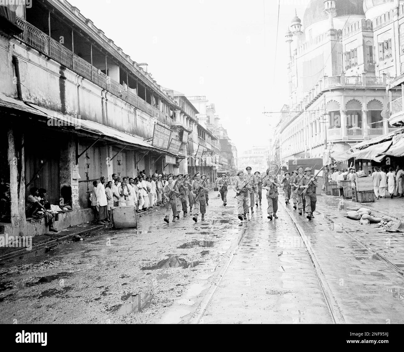 British soldiers with their guns at the ready, patrol a street in ...