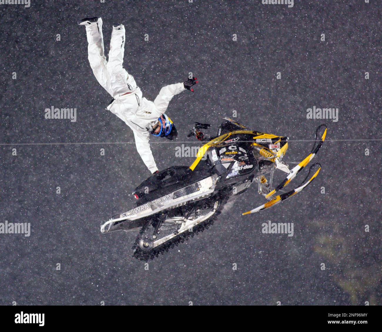 Heath Frisby hold on to his snowmobile with one hand while flying ...