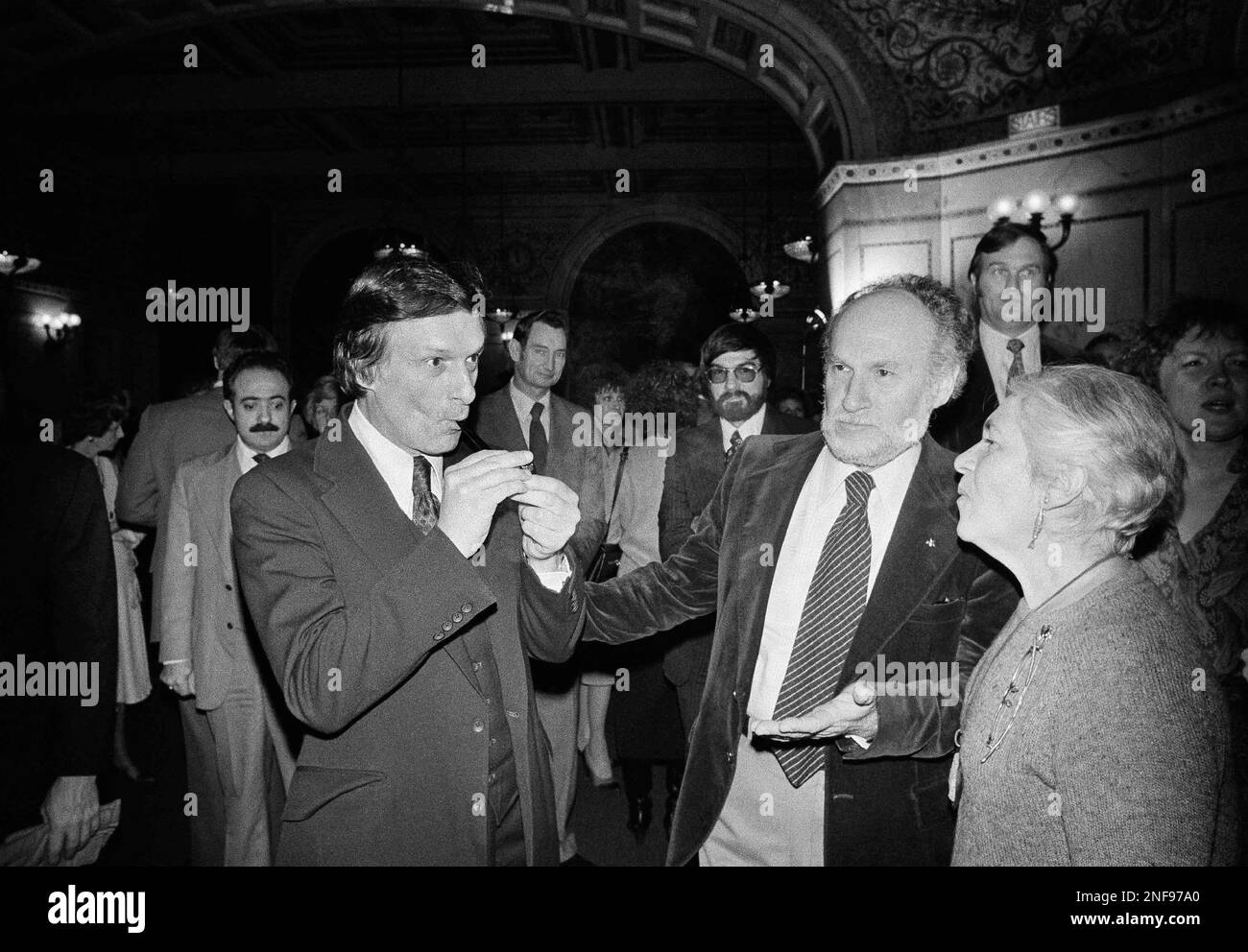 Playboy magazine founder-publisher Hugh Hefner, left, lights his pipe ...