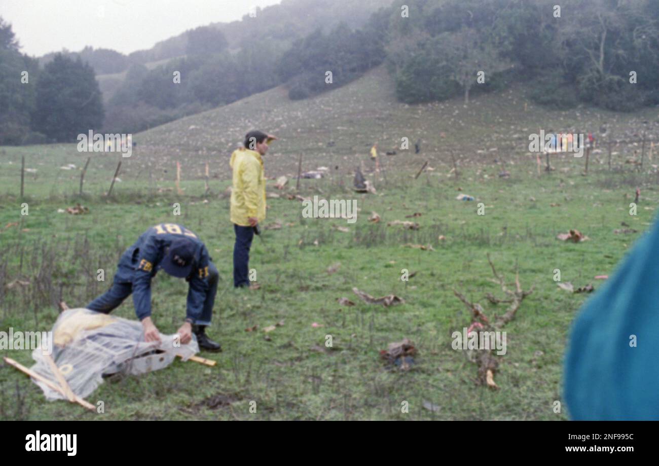 An FBI investigator packages evidence and searches for clues looking ...