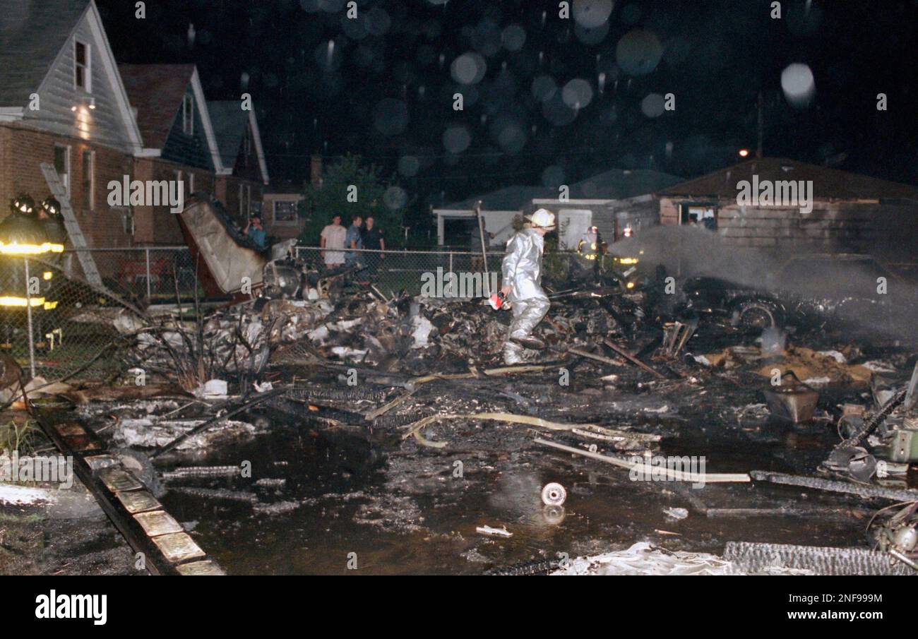 A firefighter walks through the debris of a twin-engine plane that ...
