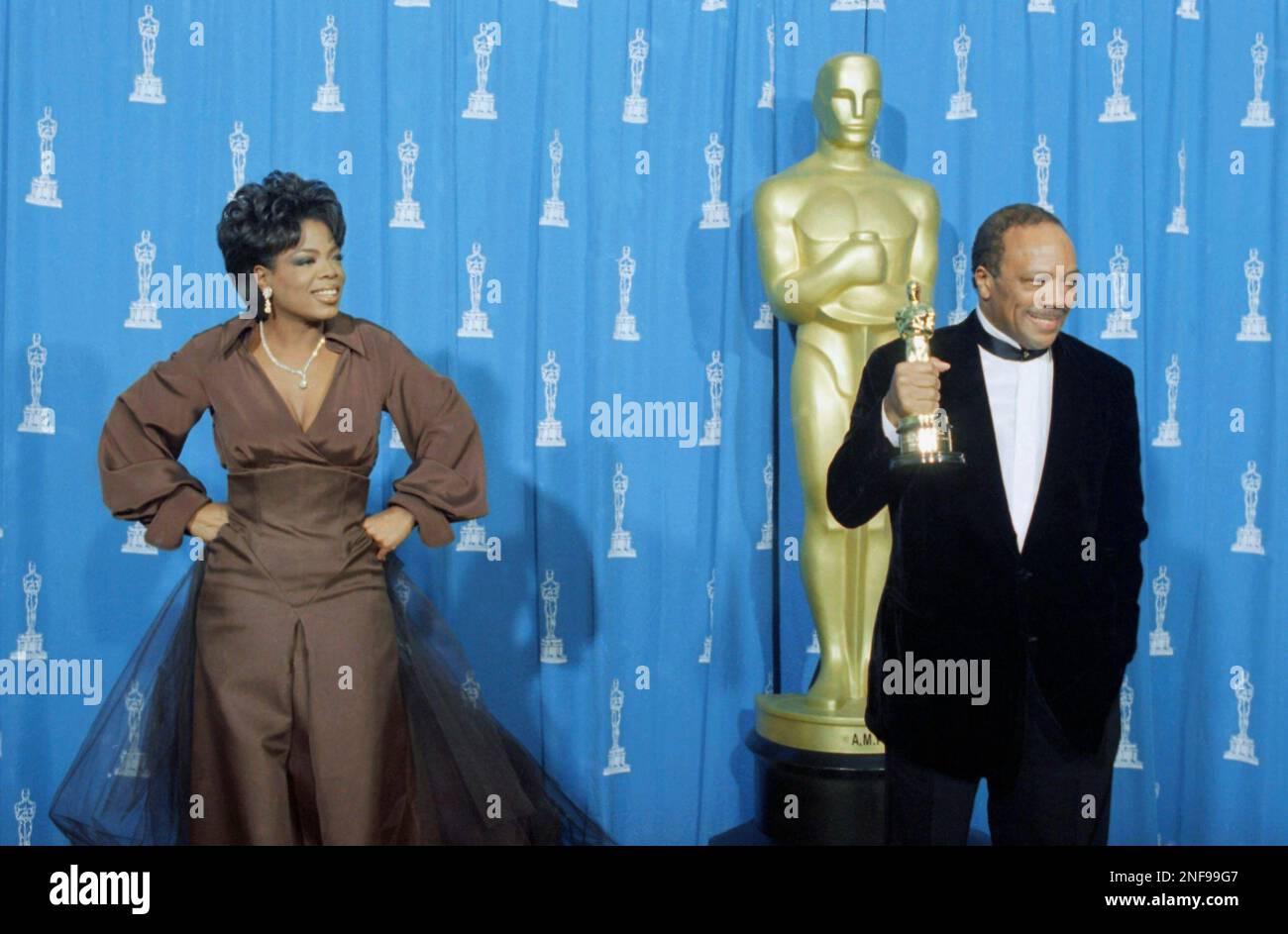 Oprah Winfrey poses with Quincy Jones as he holds his Oscar for the ...