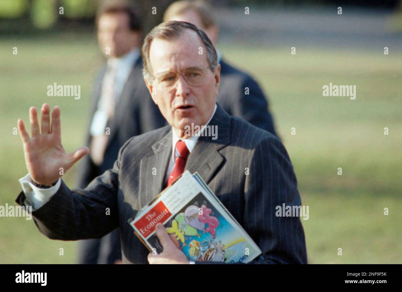 U.S. President George H. Bush carries a copy of The Economist Magazine ...