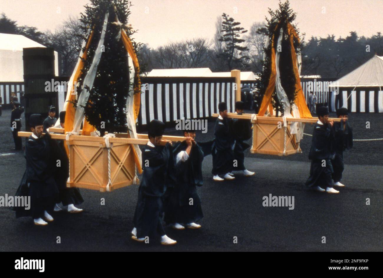 Two sacred trees are carried by Shinto priests to the alter for the ...