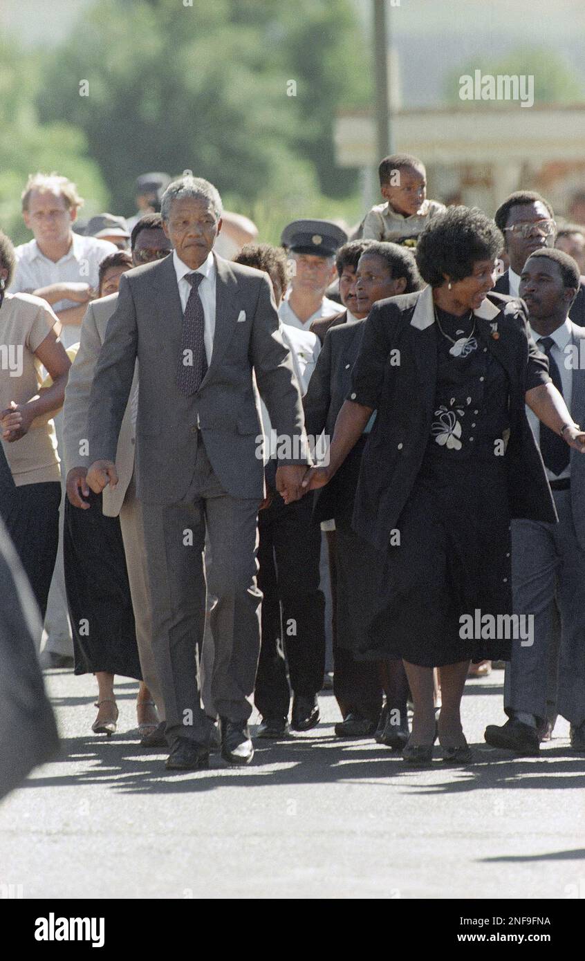Nelson Mandela is led by his wife, Winnie Mandela, after his release ...