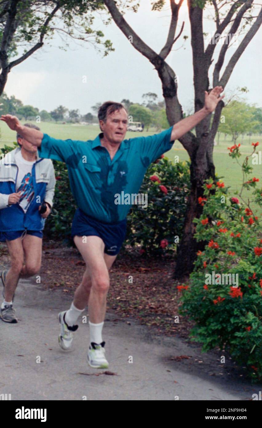 President George Bush stretches his arms while taking an early morning ...