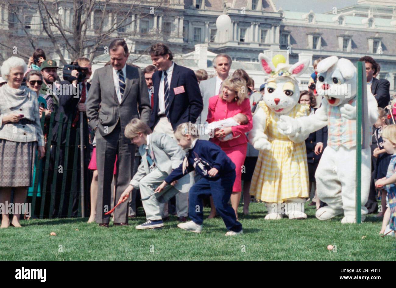 Two youngsters roll their eggs past President George Bush on the South ...