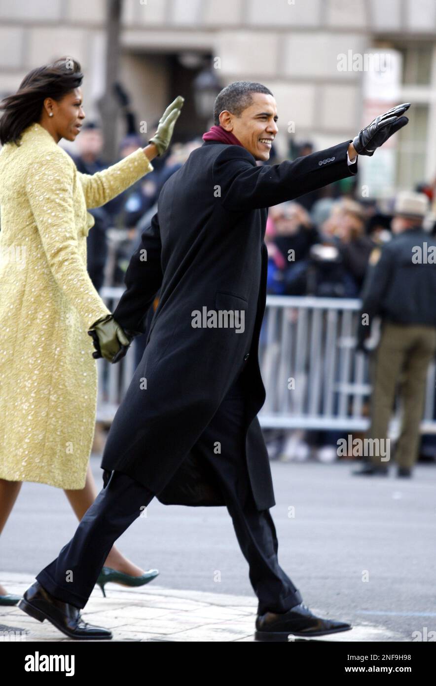 President Barack Obama and first lady Michelle Obama wave to the crowd ...