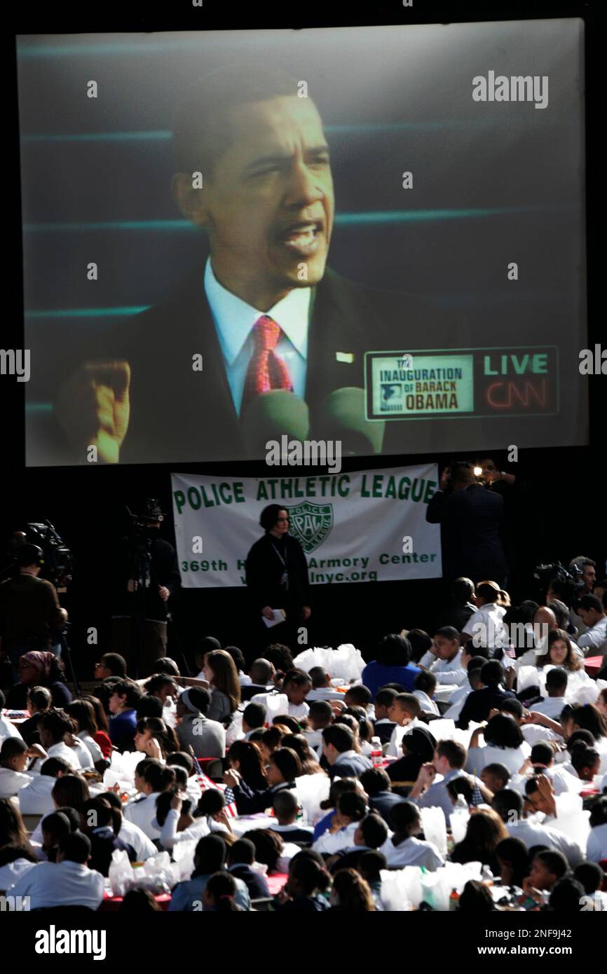 A crowd watches the inauguration ceremony of President Barack Obama via ...