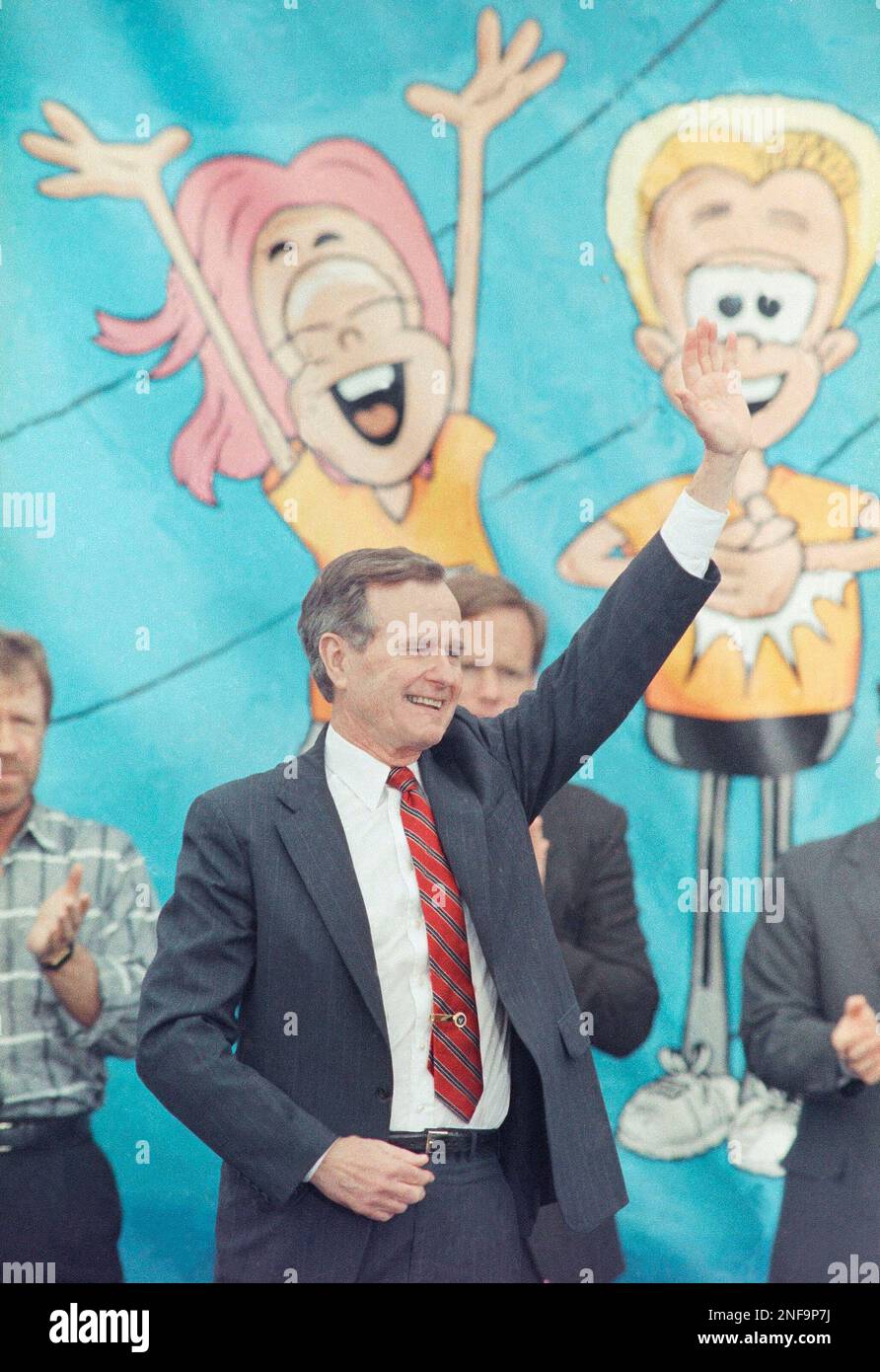 President George Bush gives the thumbs up as he acknowledges the cheers ...