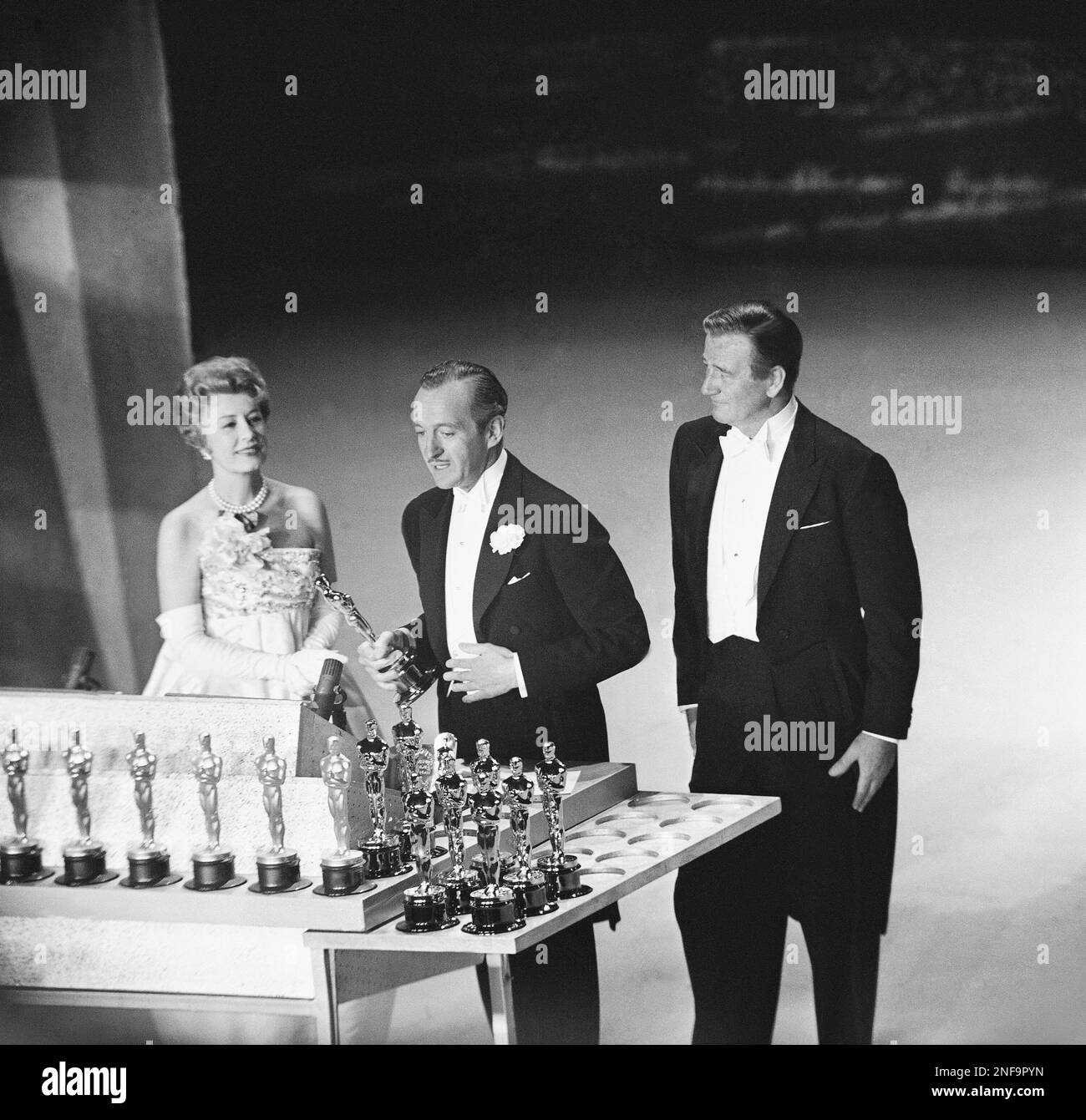 David Niven, center, holds his Oscar as he thanks the Academy of Moton ...