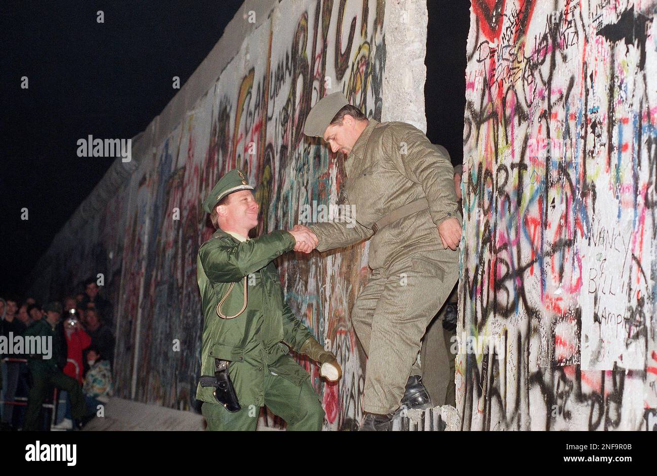 A West German policeman, left, gives a helping hand to an East German ...