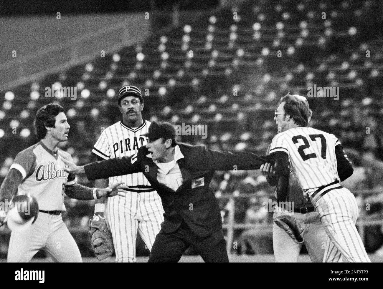 First base umpire Andy Olsen stands between Pat Rockett of the Atlanta ...