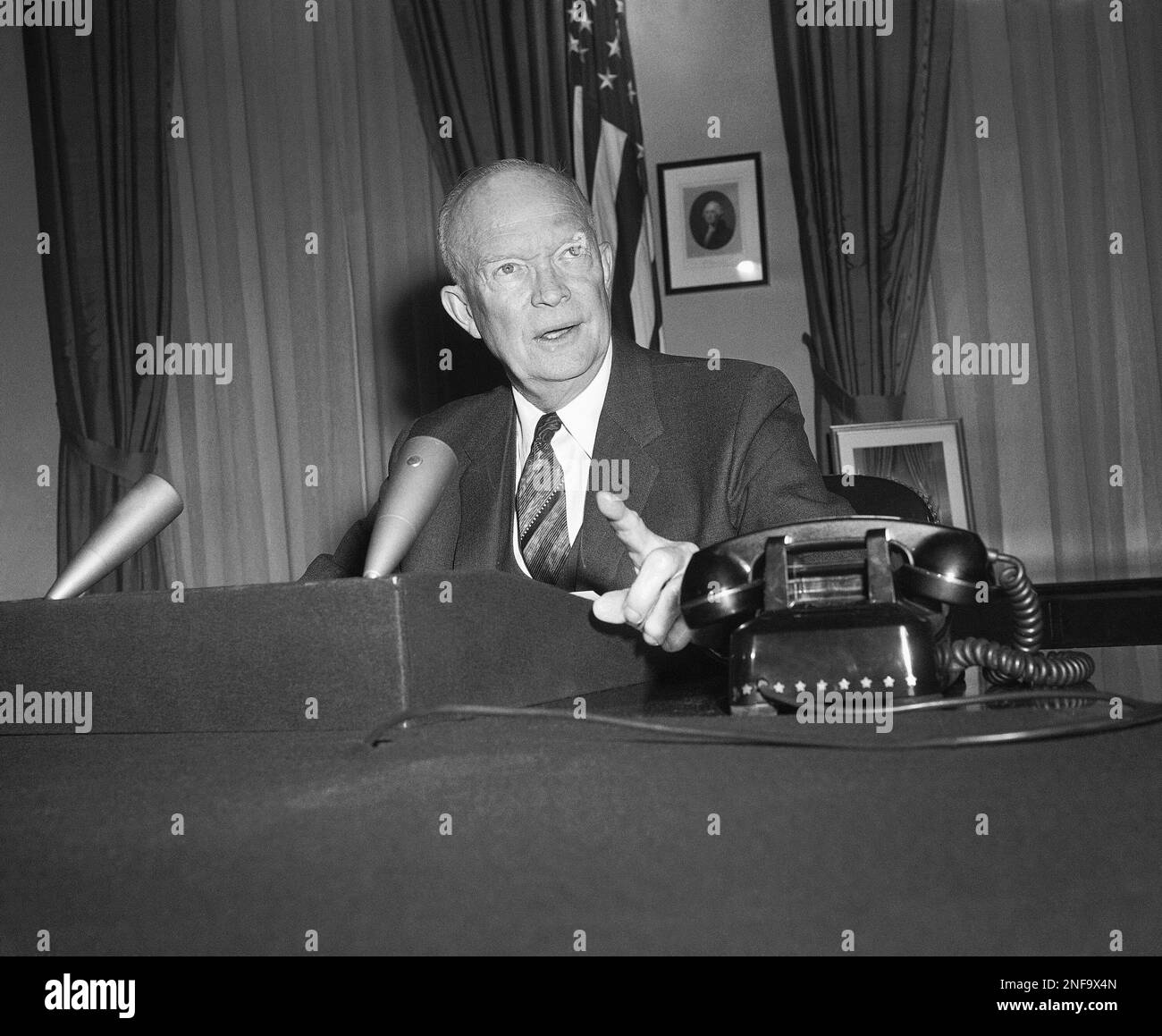 President Dwight Eisenhower poses at his White House desk just before ...