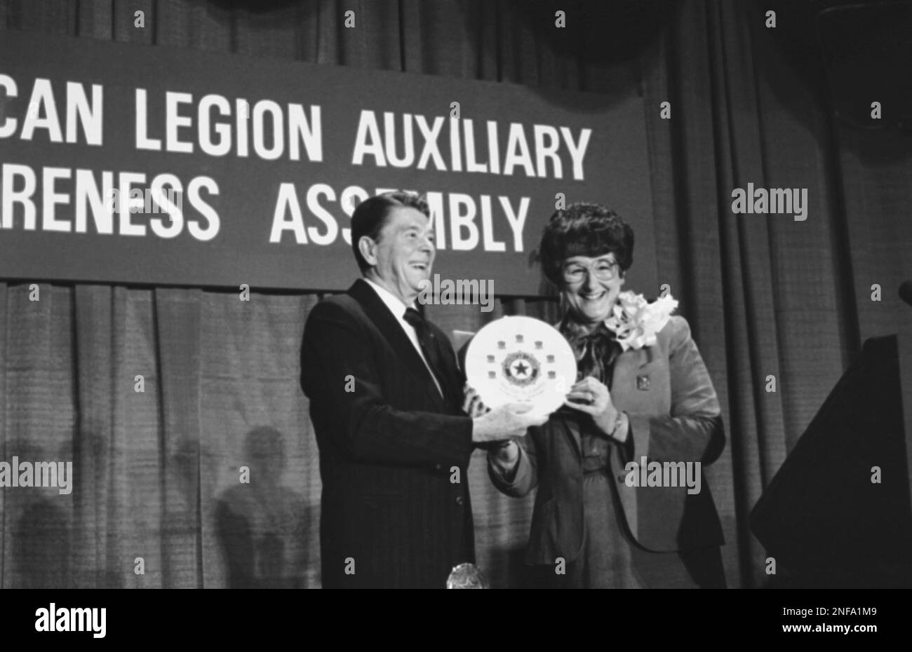 U.S. President Ronald Reagan holds up a plate presented to him by Anna ...