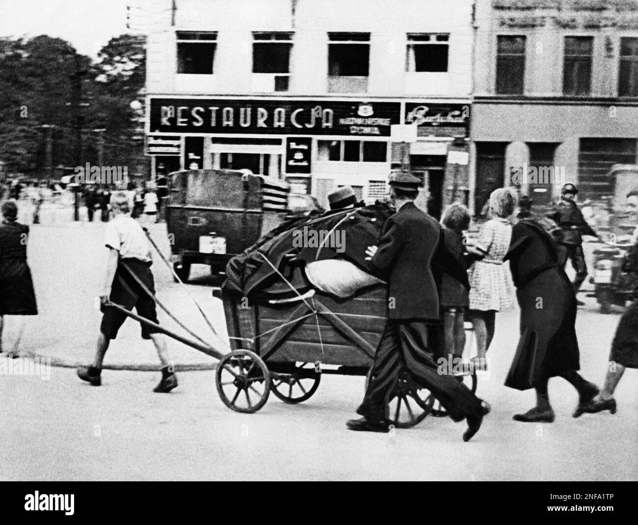 Their worldly goods loaded into a cart, a family of war refugees is ...
