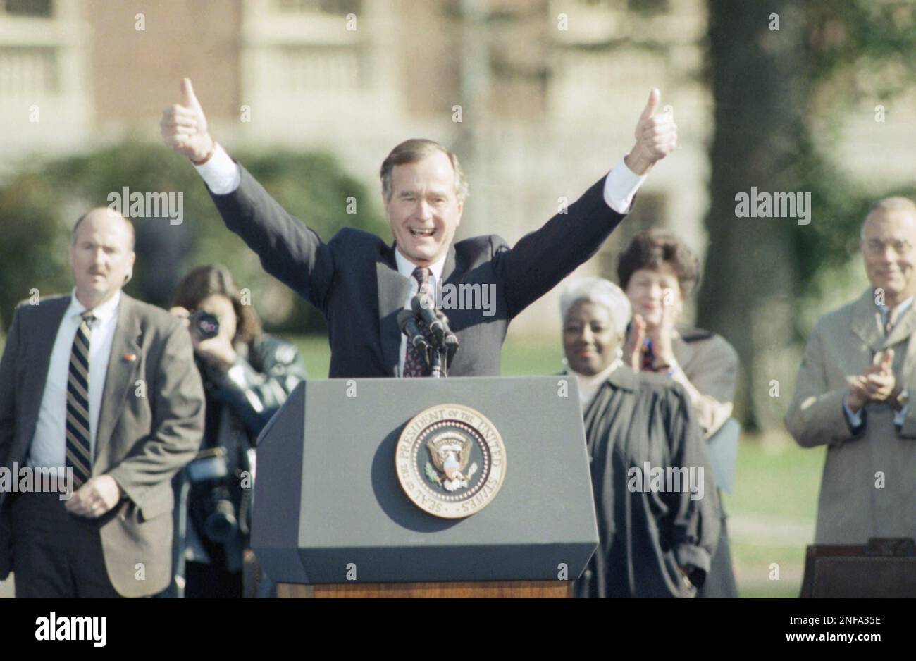 President George Bush gives the thumbs-up to a crowd of students and ...
