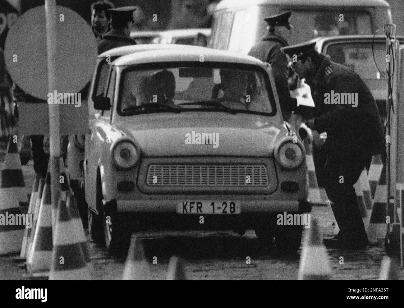 An East German customs officer talks to East Germans crossing the ...