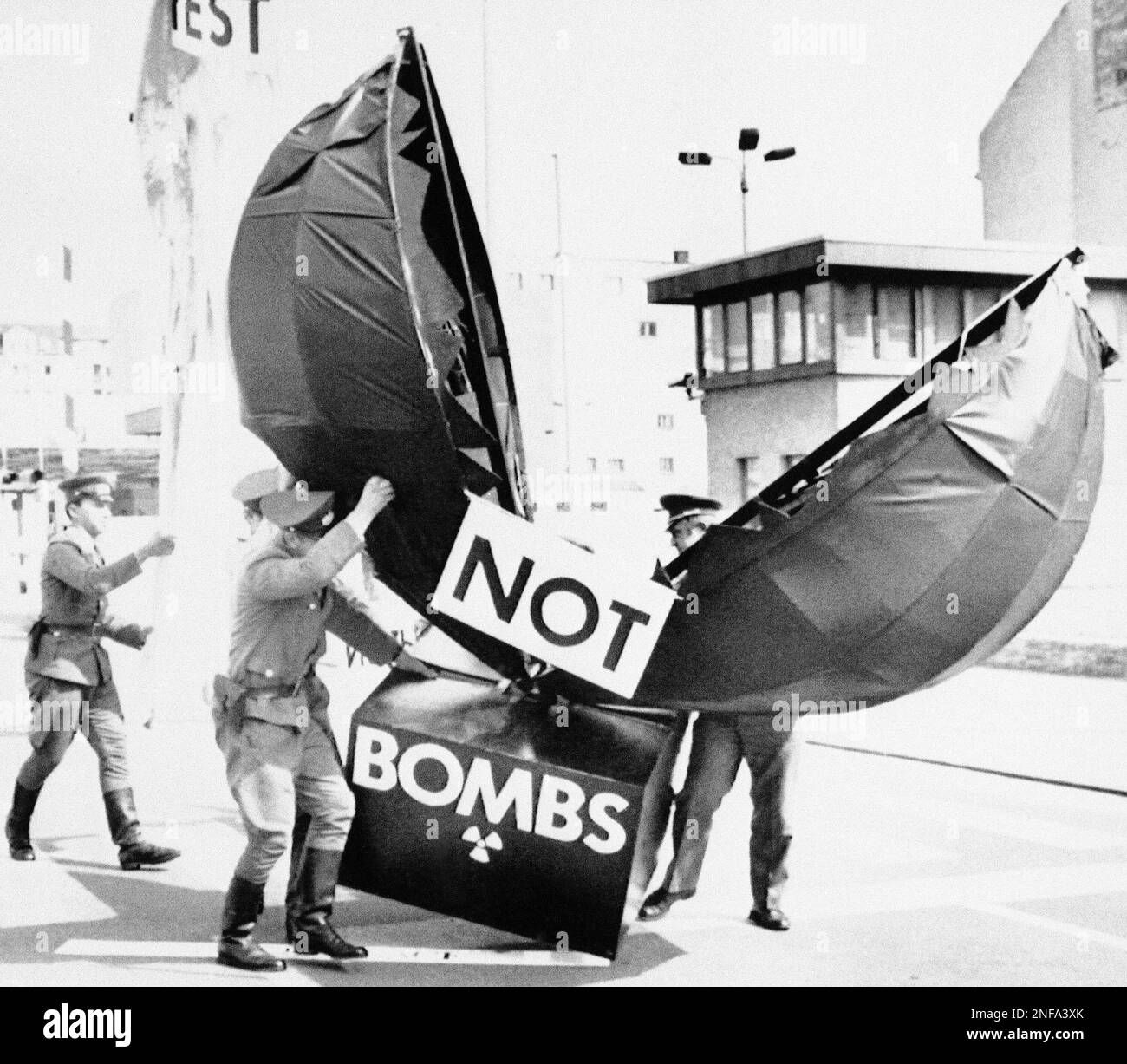 East German border guards carry a handmade model of the first atom bomb ...