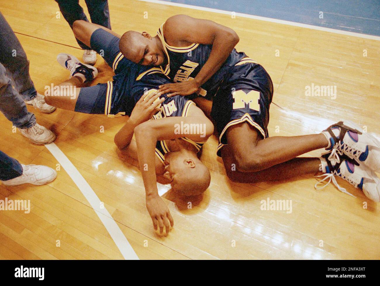 Michigan’s Juwan Howard, top, and MVP Jalen Rose, roll around in ...