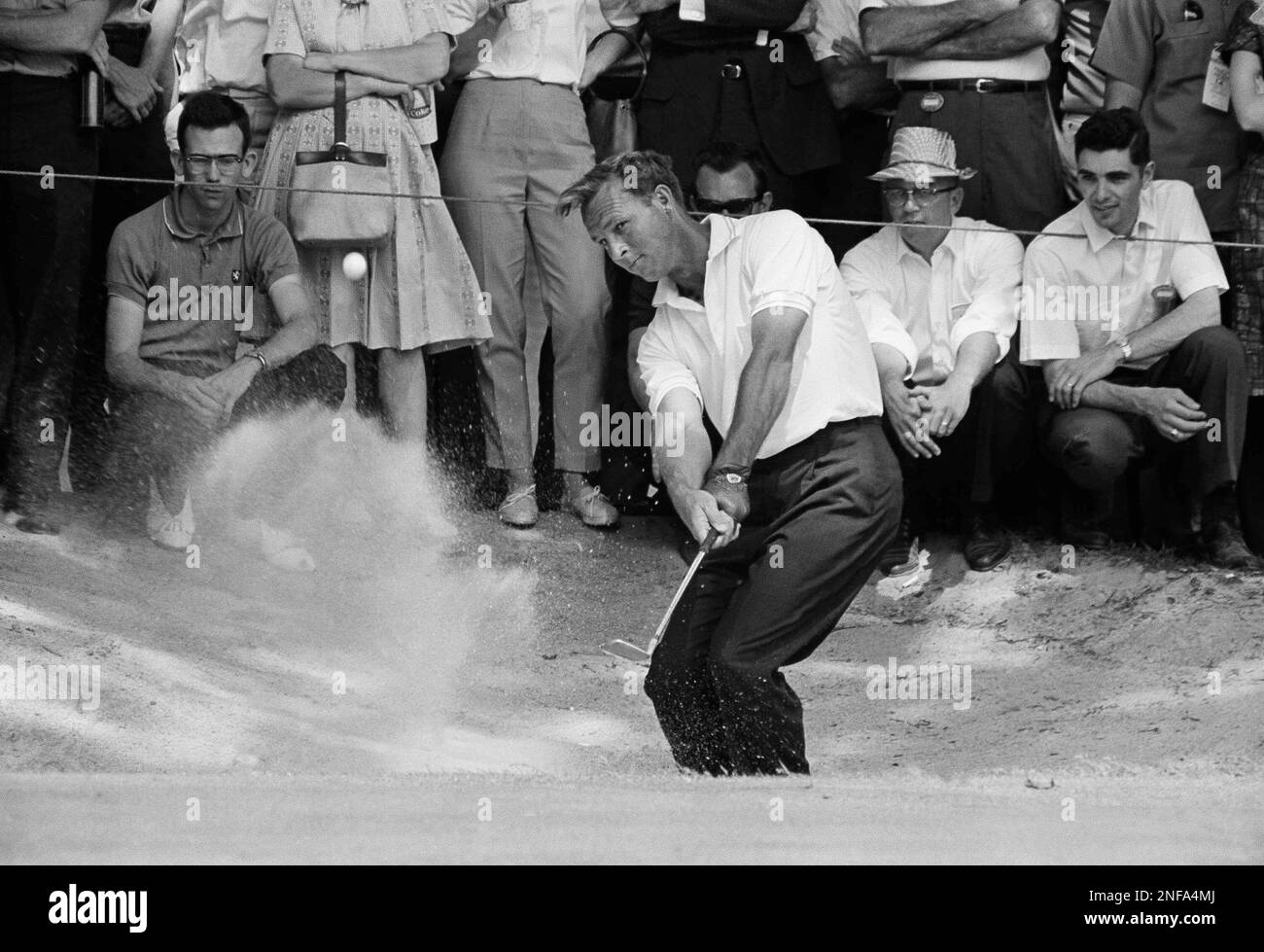 Arnold Palmer blasts from sand trap on 7th green during playoff round ...
