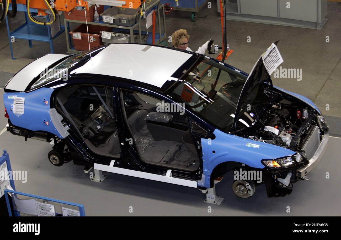 A Honda Civic is worked on as it moves along the assembly line at the ...