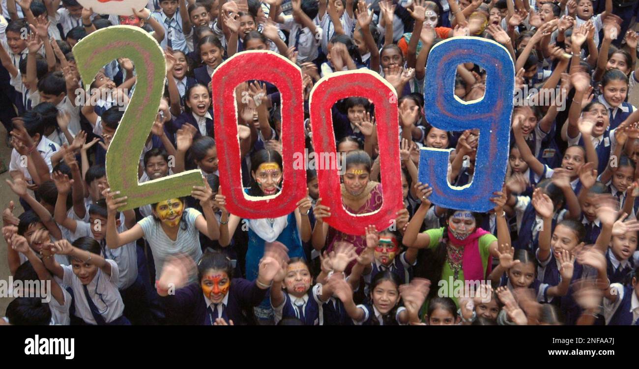 School children hold the figure 2009 as others wave during a function ...